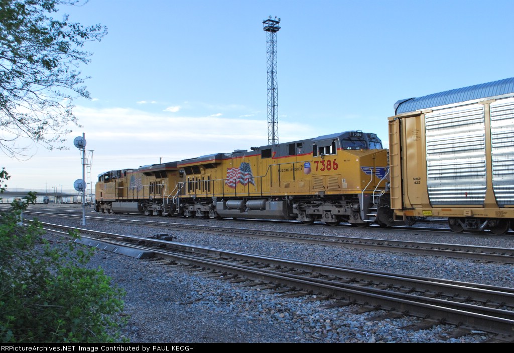 UP 7810 leads UP7386 and a vehicle train in front of the UP GR Depot. in this early am.